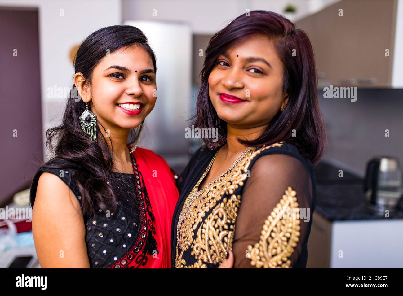 happy mixed race friends emracing hugging greeting each other in living ...