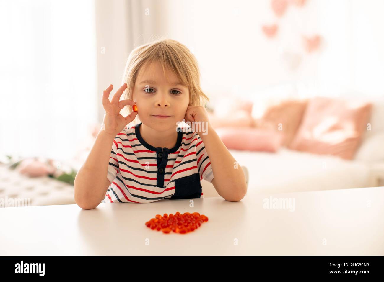 Cute little child, toddler boy, eating alfa omega 3 child suplement ...