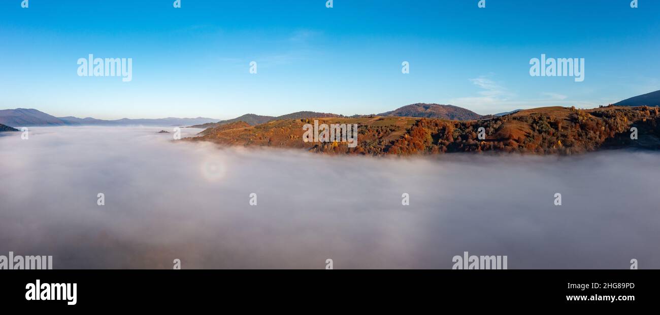 Thick layer of fog descended into canyon among peaks of high mountains ...