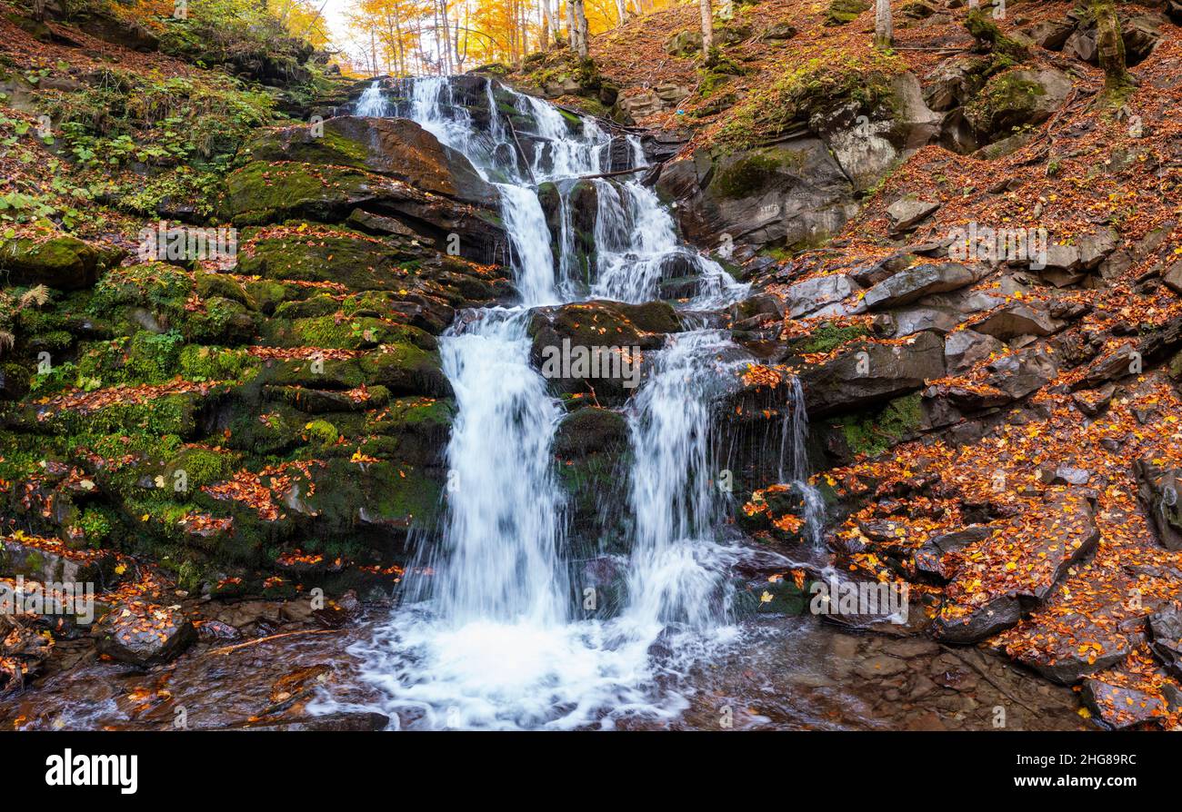 Narrow waterfall stream falling down rocks and stones of mountain steep ...