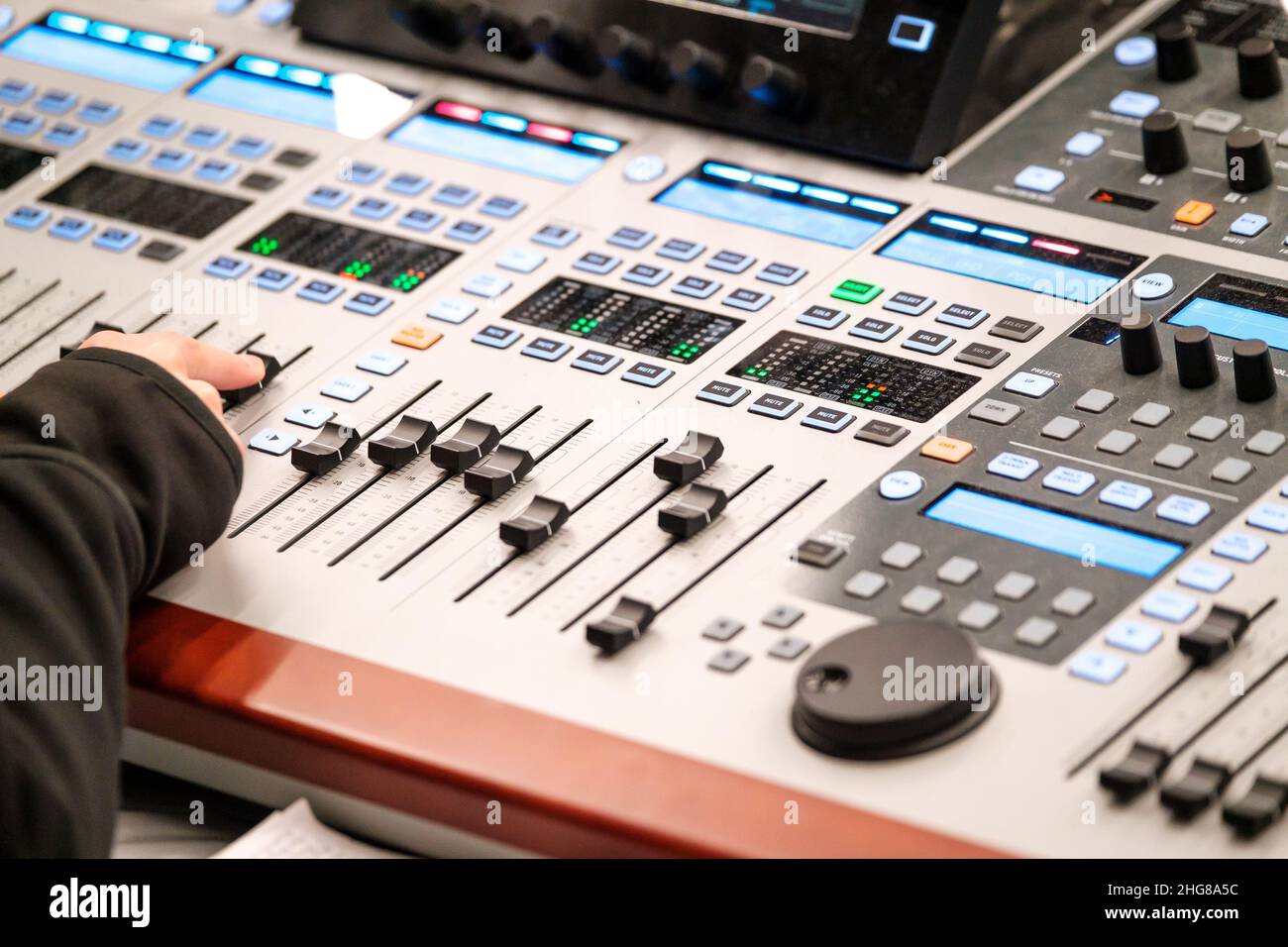 Crop audio engineer adjusting sound and volume on modern mixing panel ...