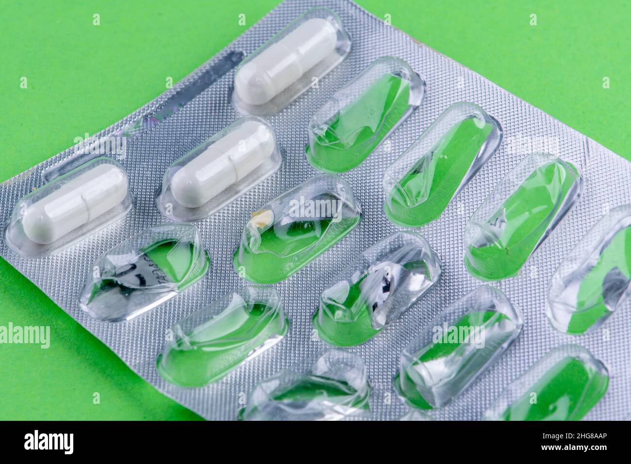 Tablets in the empty tablet packaging on green Stock Photo - Alamy
