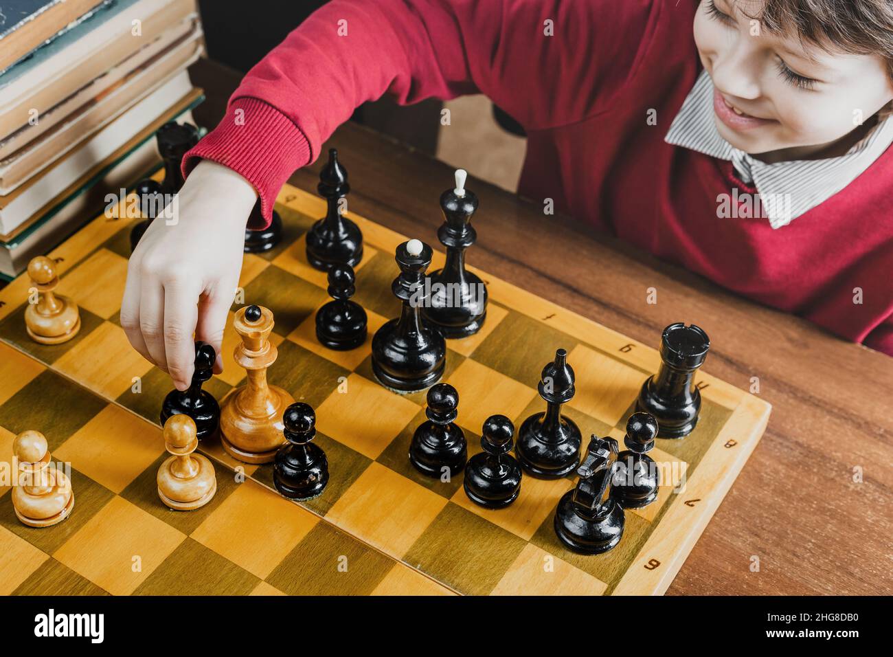 Happy kid defeating a queen figure while playing chess Stock Photo - Alamy