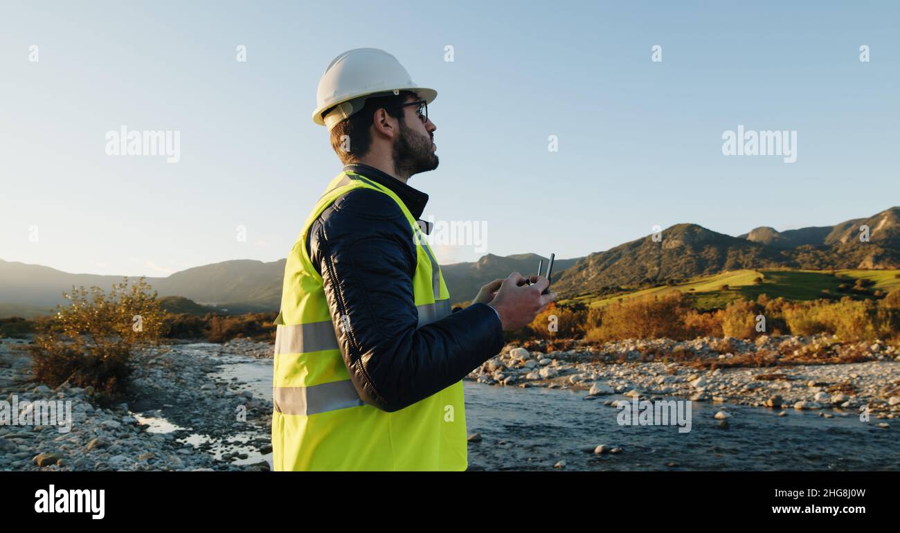 engineer with remote controller of drone checks the state of the ...