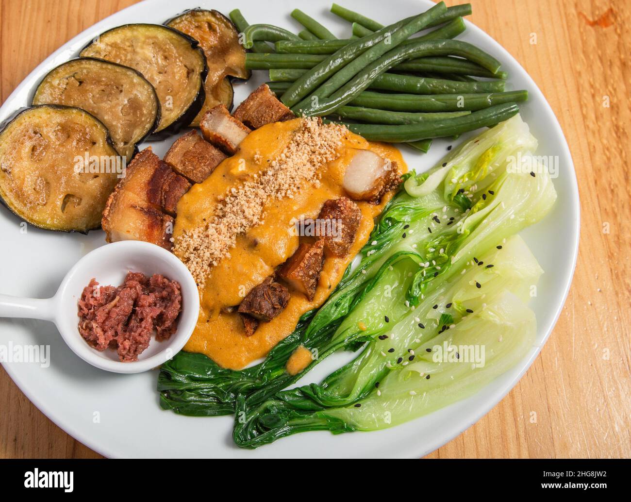 Crispy kare kare, pork belly are sauce with peanuts and vegetables ...