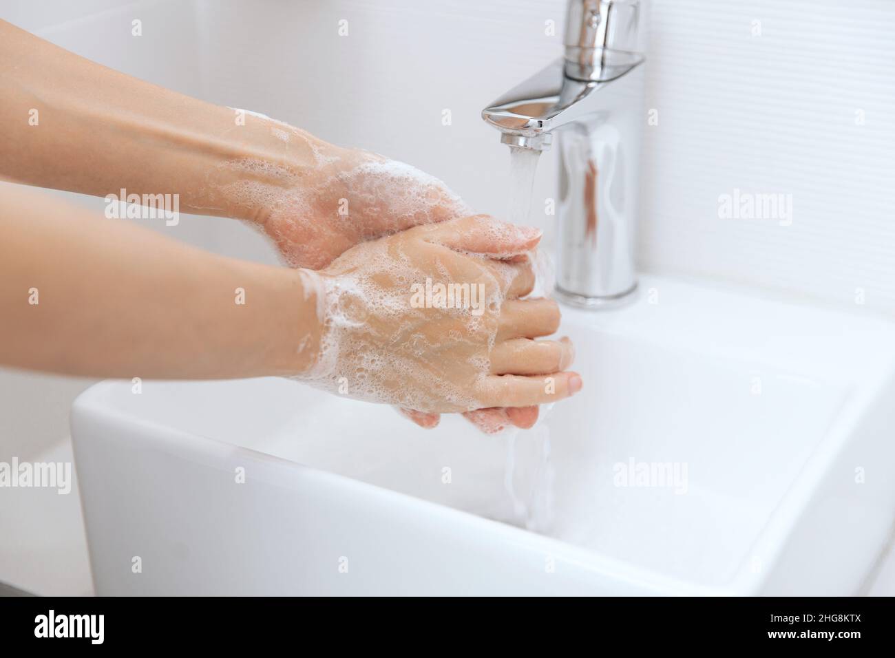 Washing hands under the flowing water tap. Hygiene concept hand detail ...