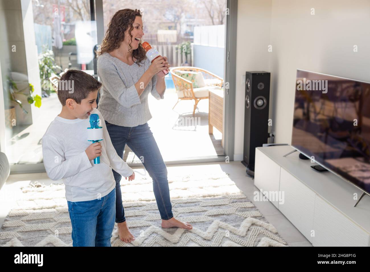 Mother and son singing karaoke at home Stock Photo - Alamy