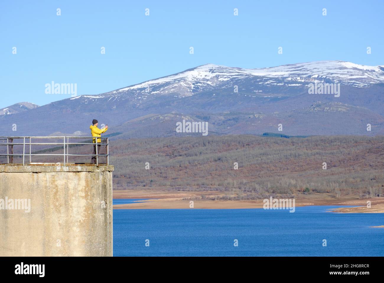 a man takes a picture with his smartphone from a lookout point above ...