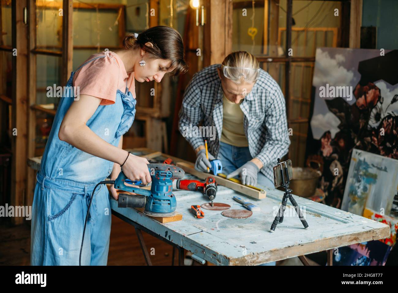 Man and woman working in workshop, doing furniture, reuse old materials ...