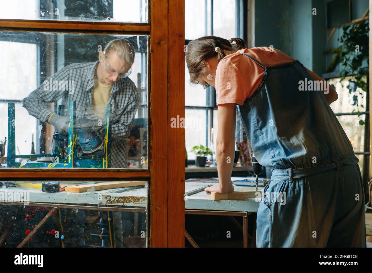 Man and woman working in workshop, doing furniture, reuse old materials ...