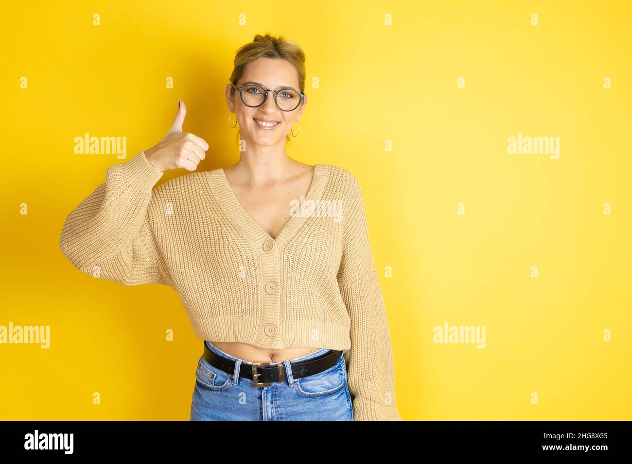 Young beautiful woman wearing casual sweater over isolated yellow ...
