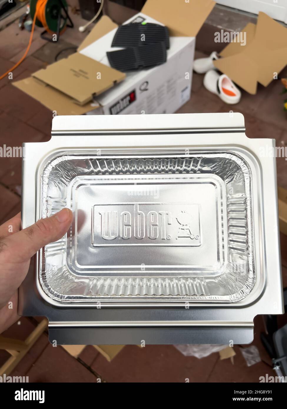 Paris, France - Dec 20, 2021: POV male hand holding new Weber barbeque ...