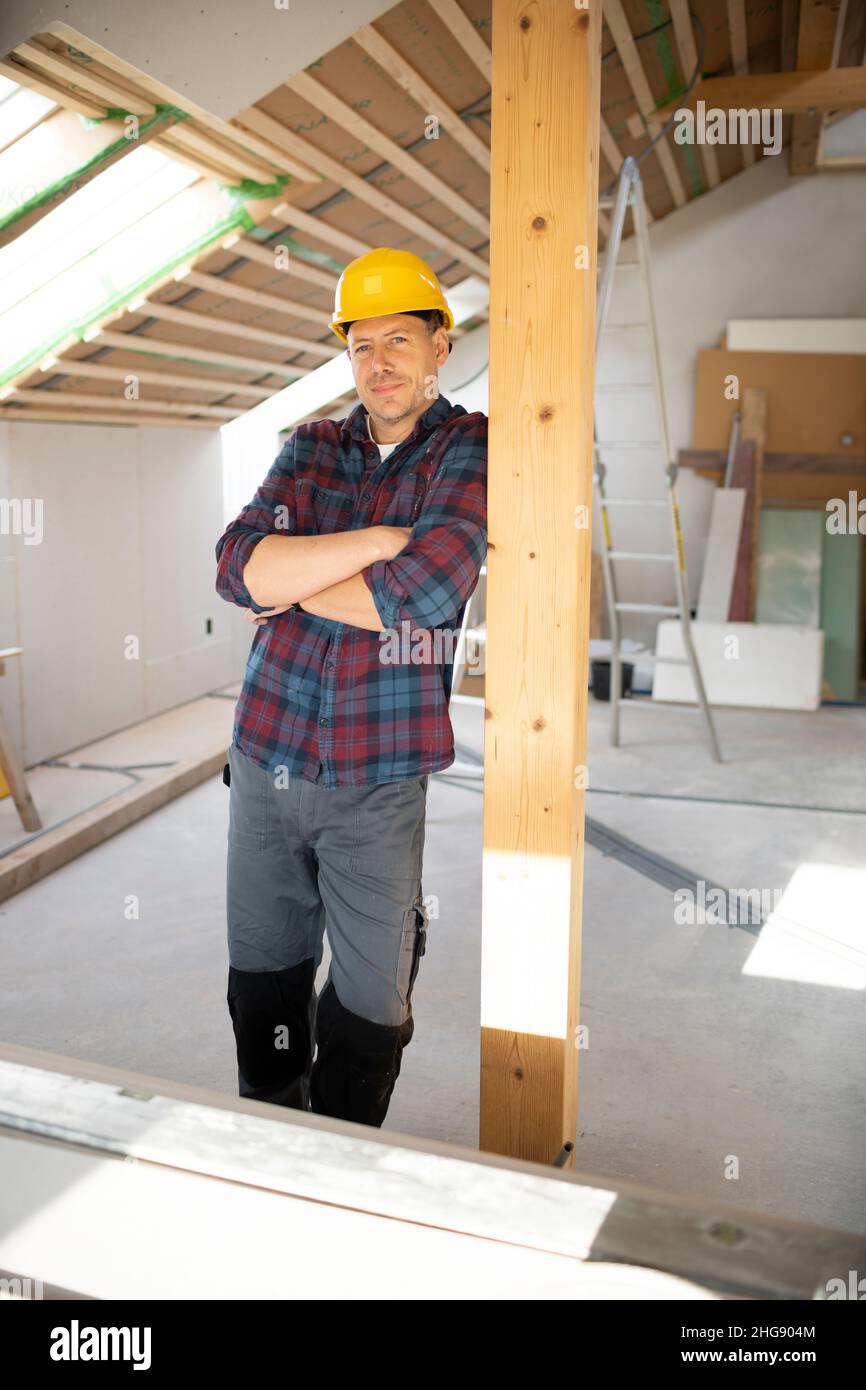 drywall worker with yellow safety helmet works on building site in a ...