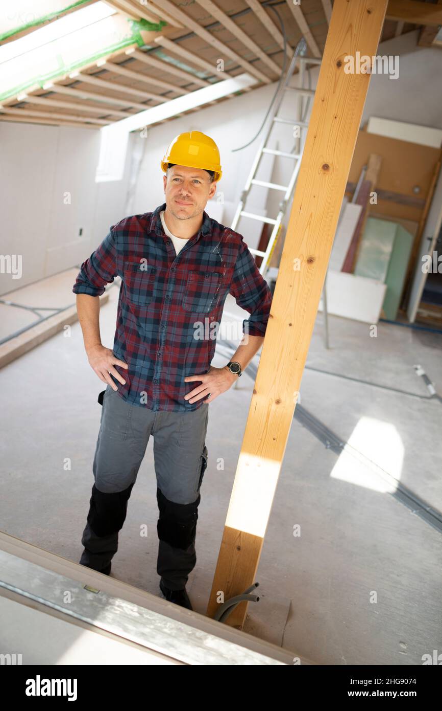 drywall worker with yellow safety helmet works on building site in a ...