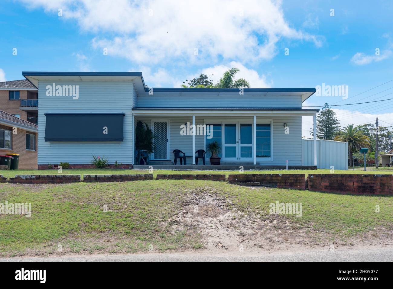 A mid century modern, timber weatherboard home with a skillion flat ...