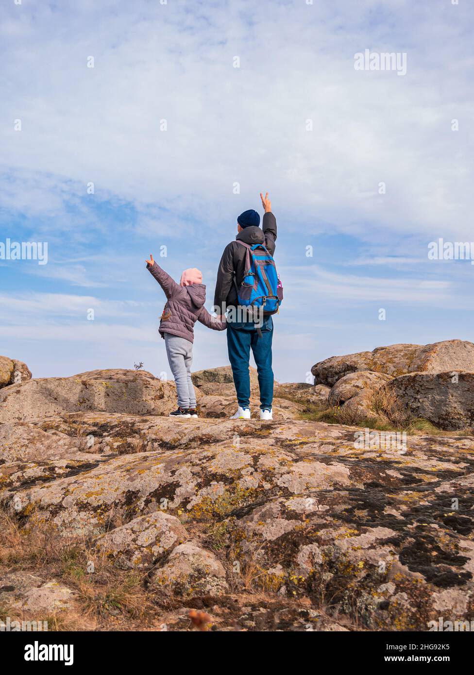 Travelers father daughter with raised hands walking climbing on ...