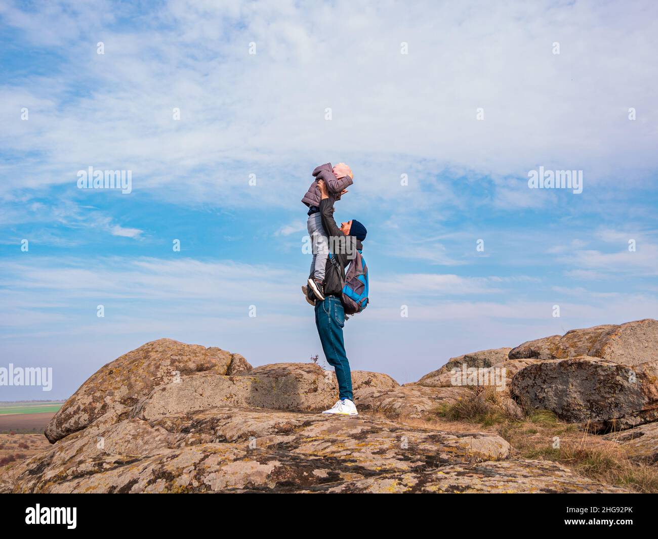 Travelers father with daughter in hands on mountain summit enjoying ...