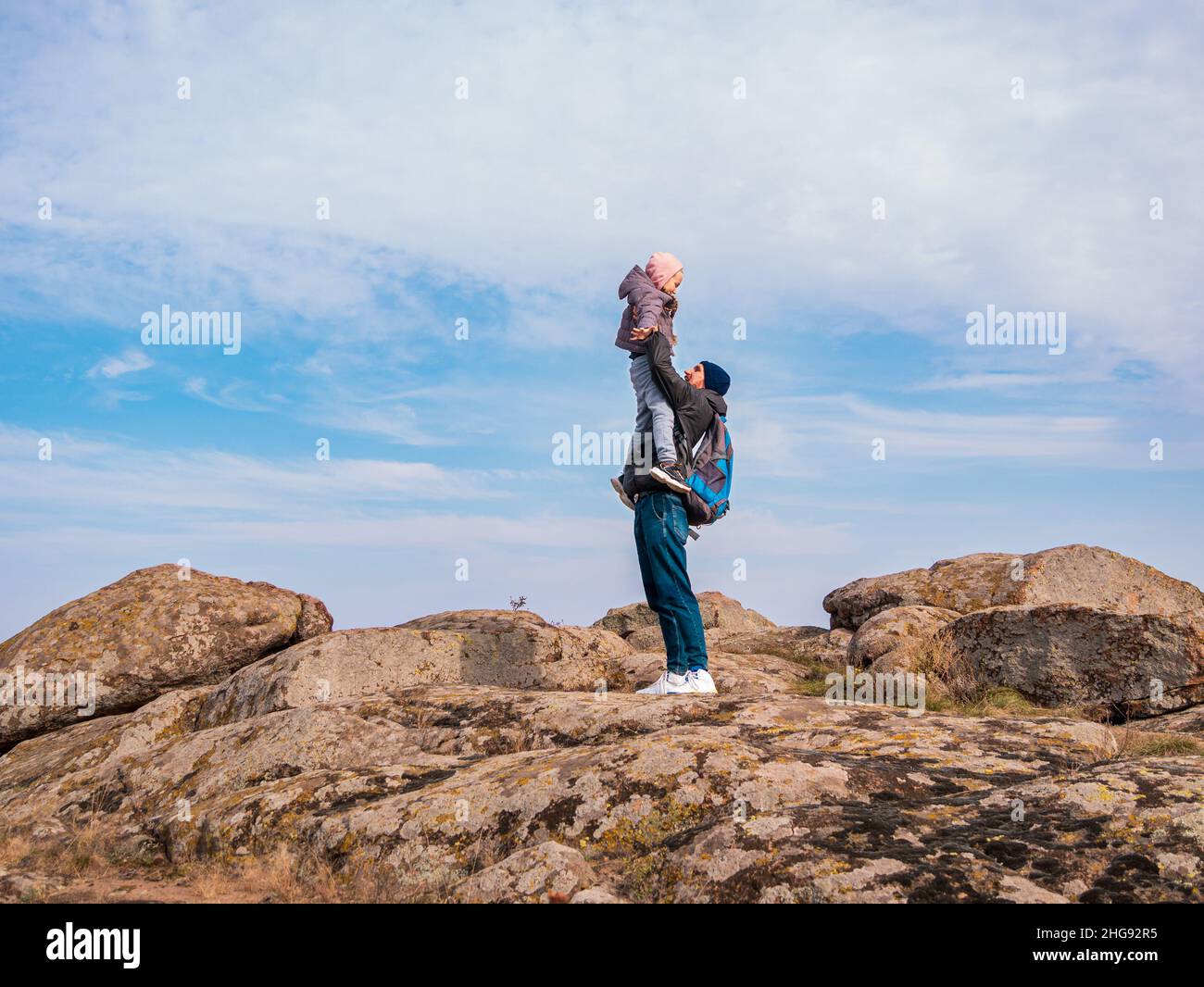 Travelers father with daughter in hands on mountain summit enjoying ...