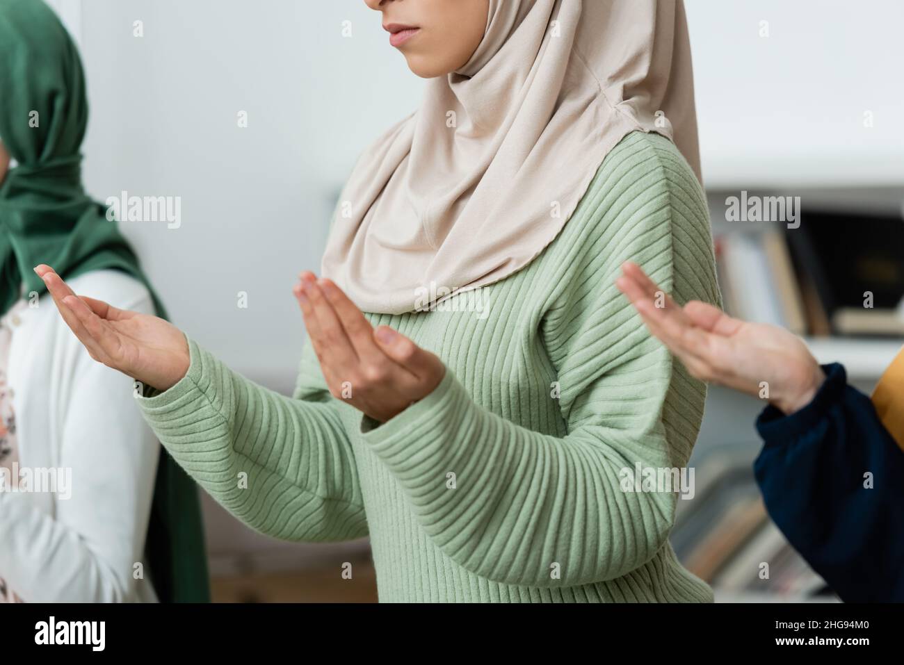 Cropped view of arabian woman praying near family at home Stock Photo - Alamy