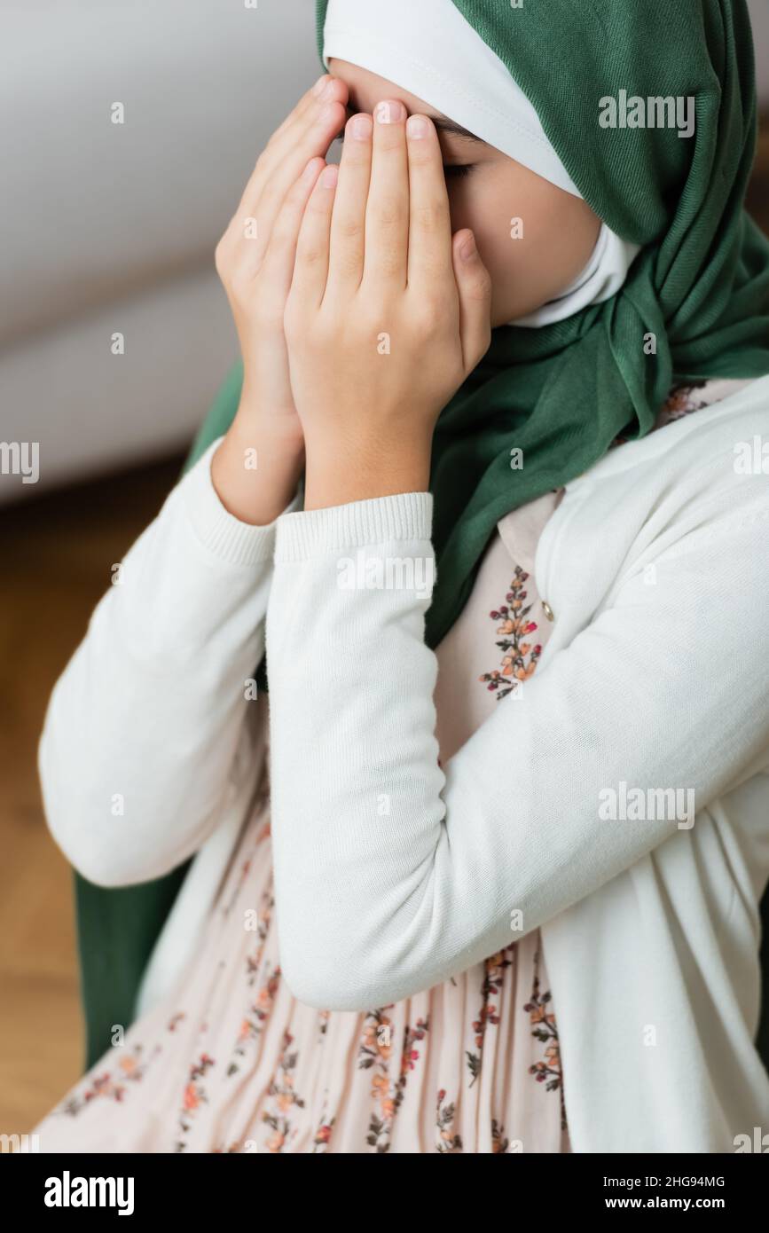 Teen kid covering face while praying at home Stock Photo - Alamy
