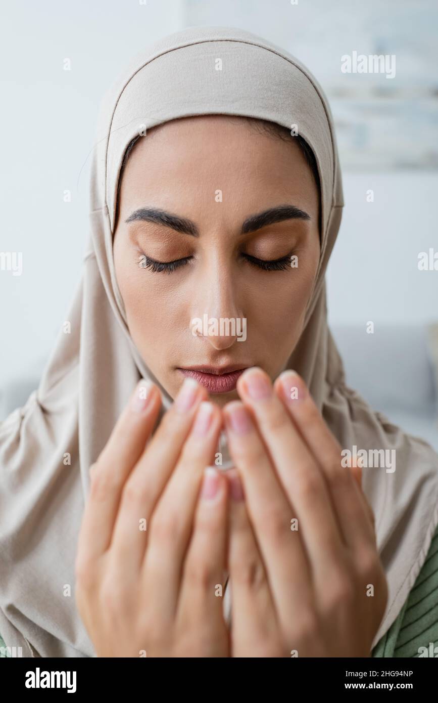 Portrait of young arabian woman praying with closed eyes Stock Photo ...