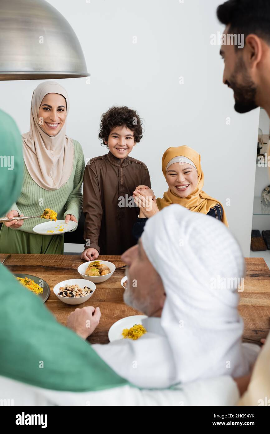 Multicultural muslim family smiling near food on table at home Stock ...
