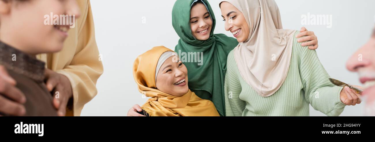 Smiling interracial muslim family hugging at home, banner Stock Photo ...