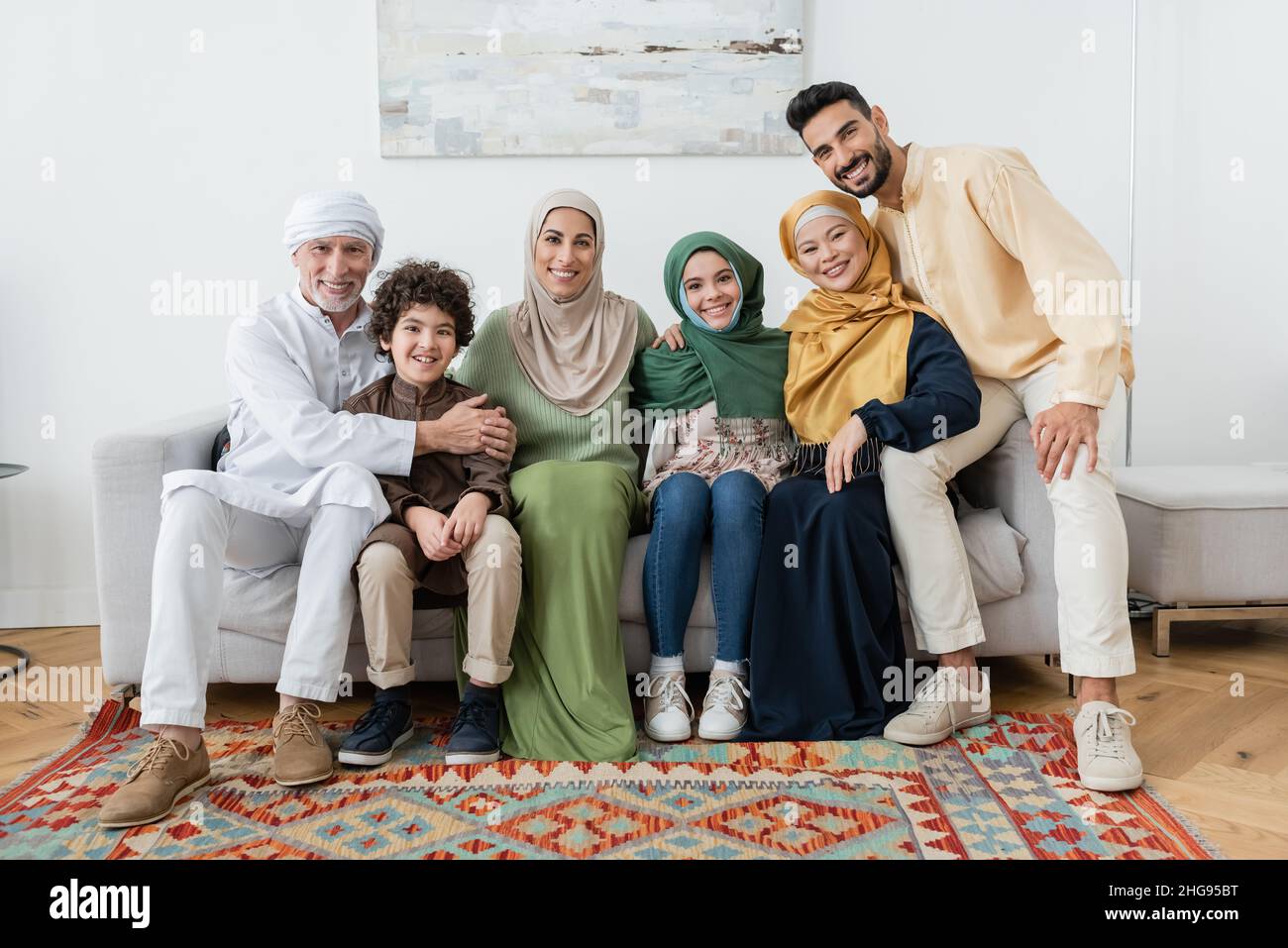 happy multiethnic muslim family looking at camera on sofa at home Stock ...