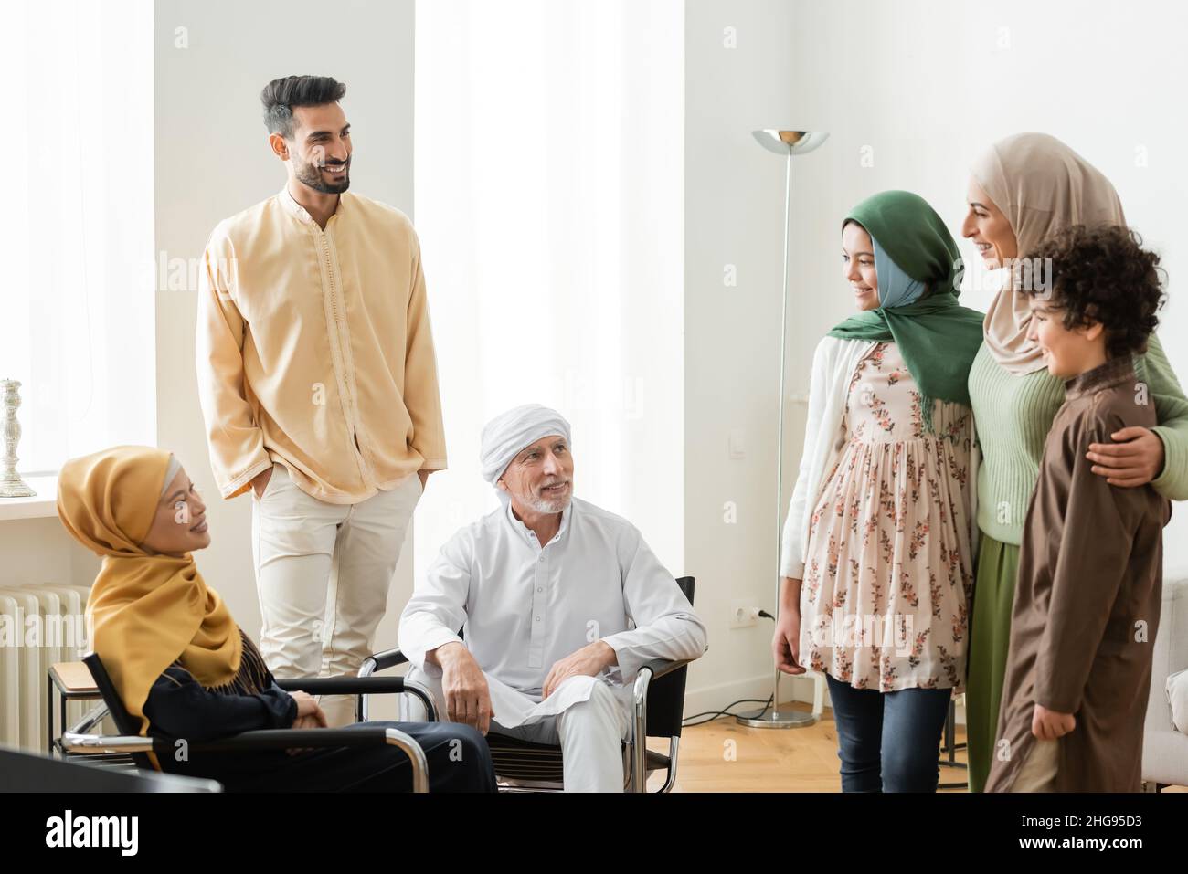 smiling arabian woman hugging kids near multiethnic muslim family at ...
