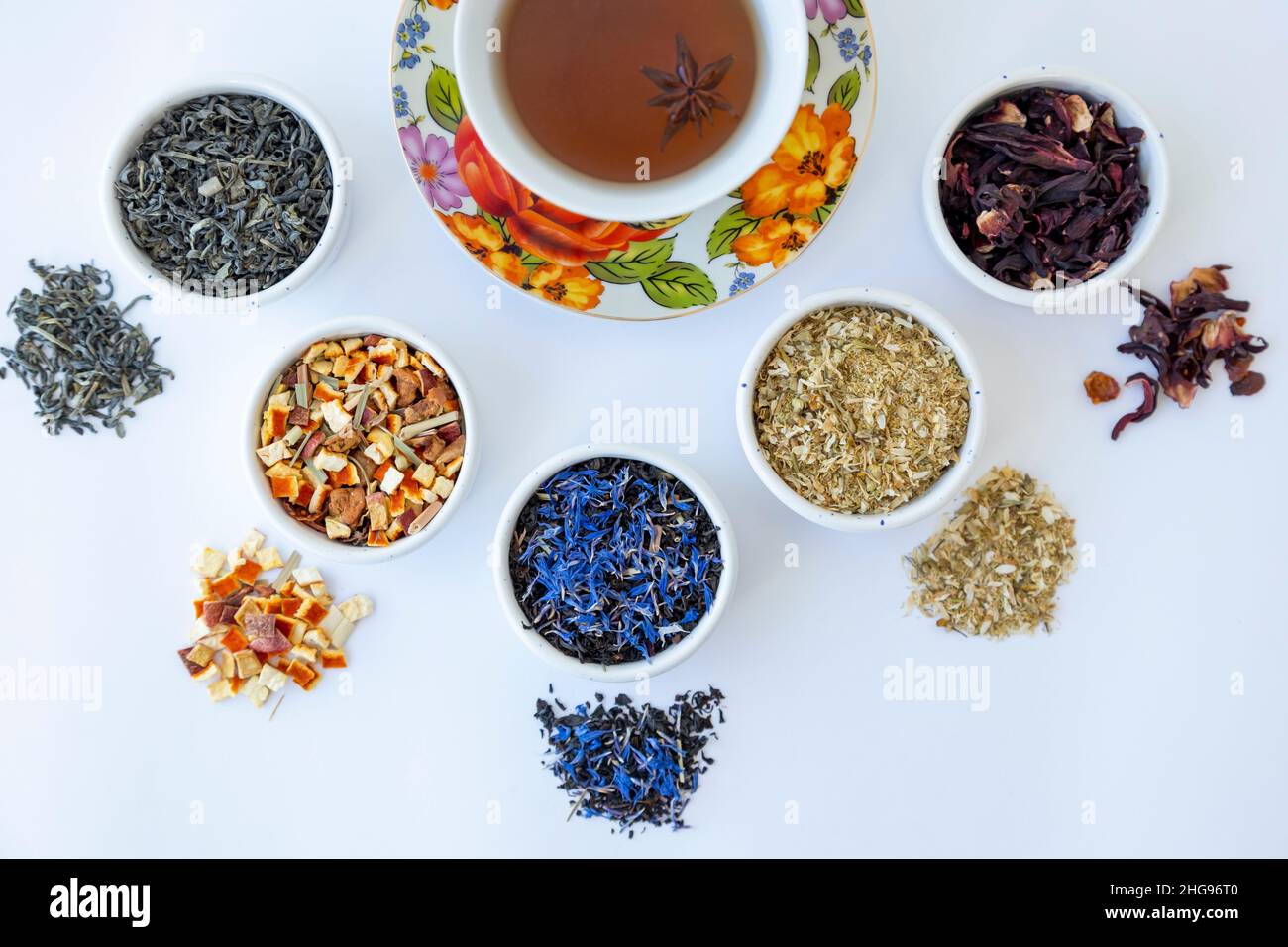 Top view. Different varieties of tea are scattered on the white table ...