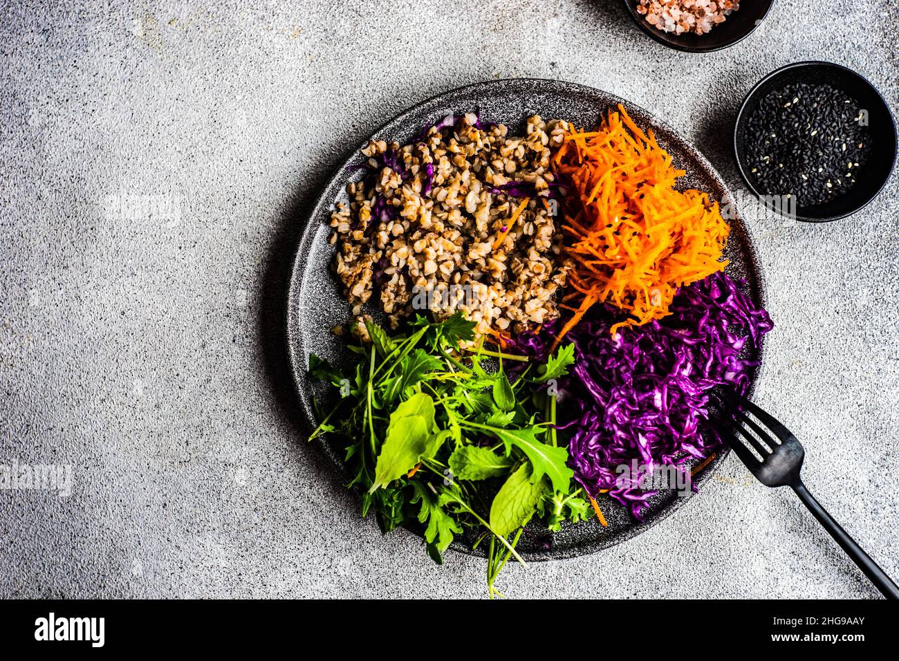 Overhead view of a plate with buckwheat, carrot, red cabbage, rocket ...