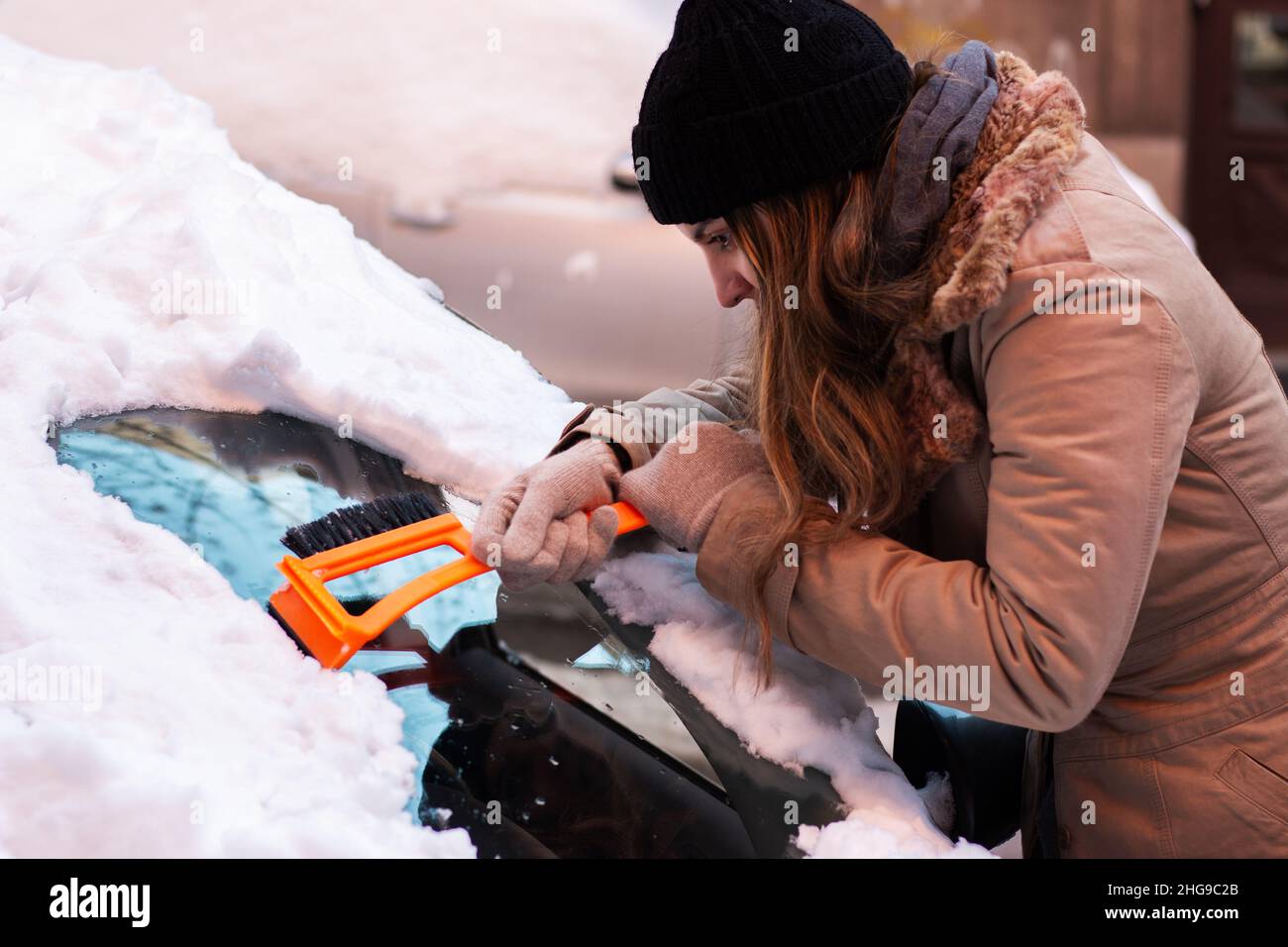 A girl removing snow and ice from the car Stock Photo - Alamy