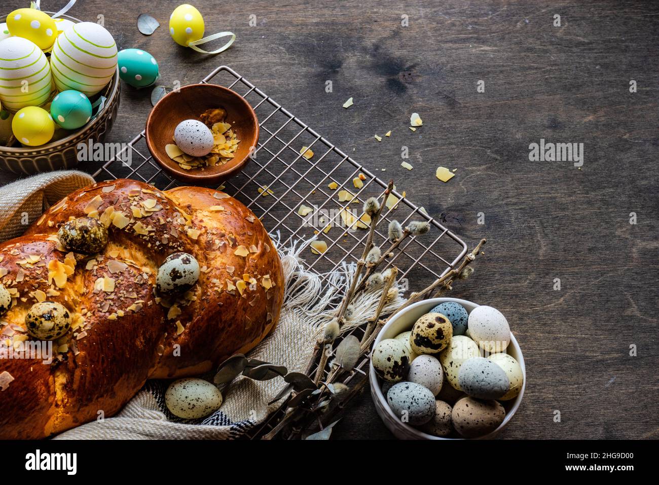 Traditional tsoureki Easter loaf with almonds on a cooling rack next to ...