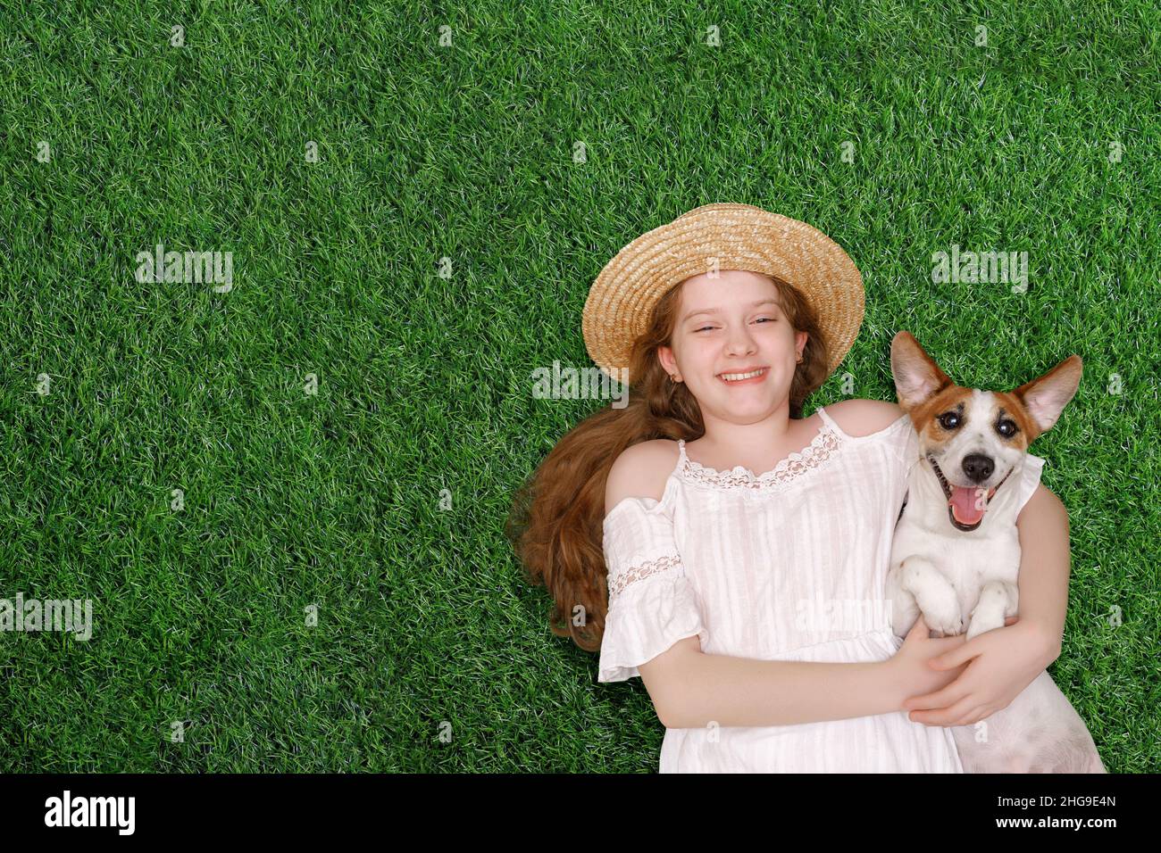Cute girl and dog enjoy spring day on the grass in the park Stock Photo ...