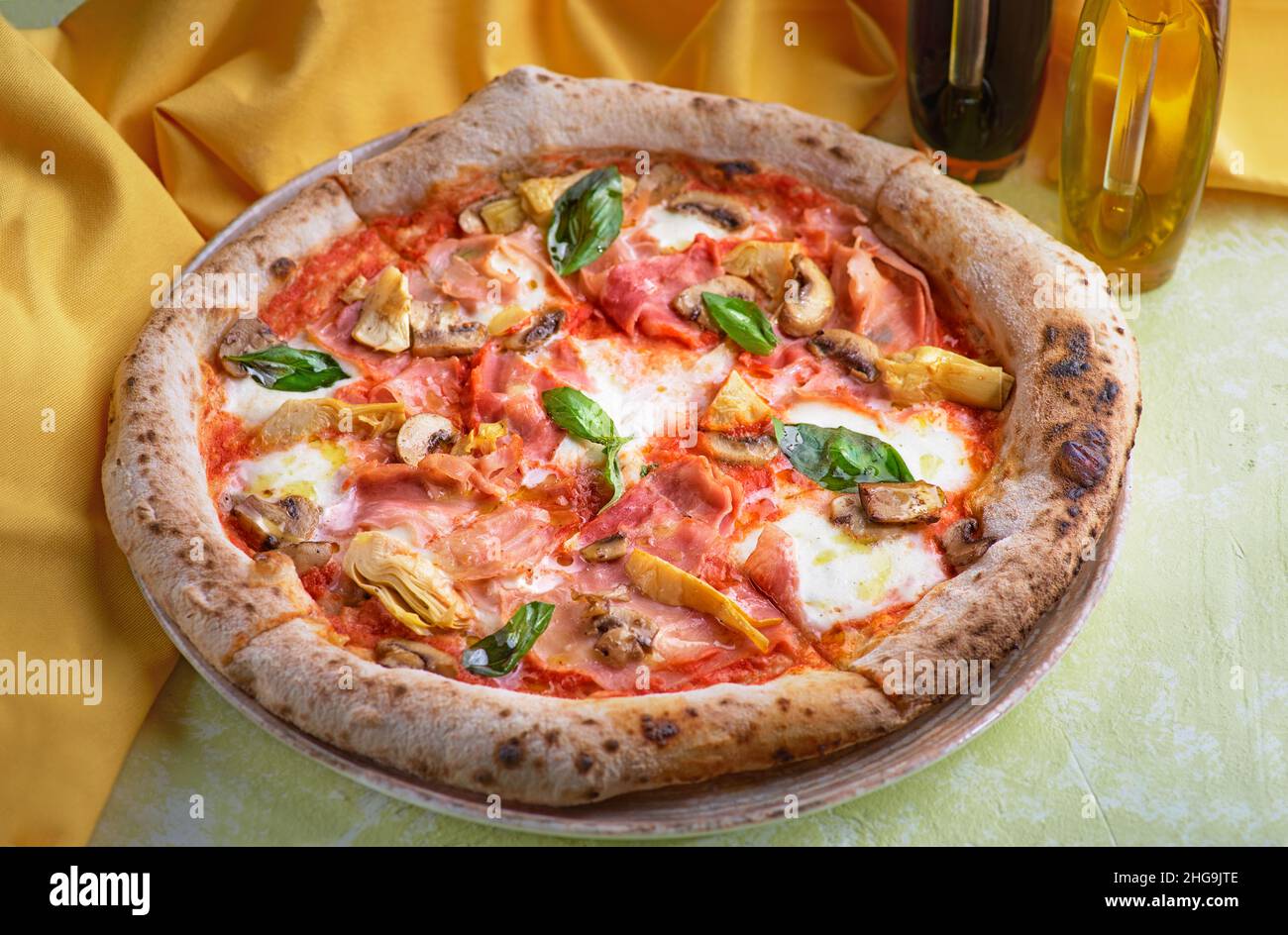 Capricciosa pizza with cheese, bacon and tomatoes and basil ...