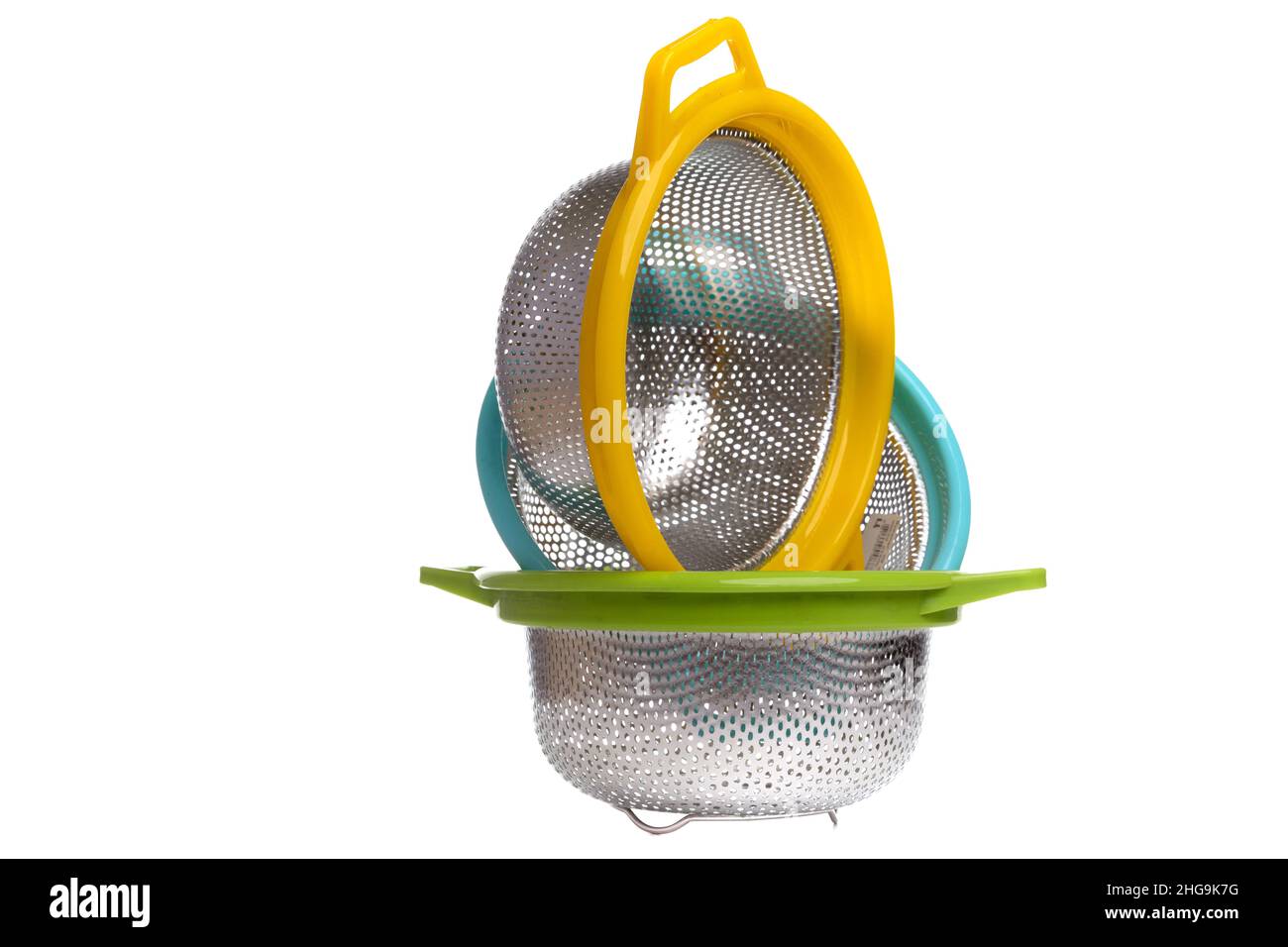 set of multi-colored aluminum colanders on a white isolated background ...