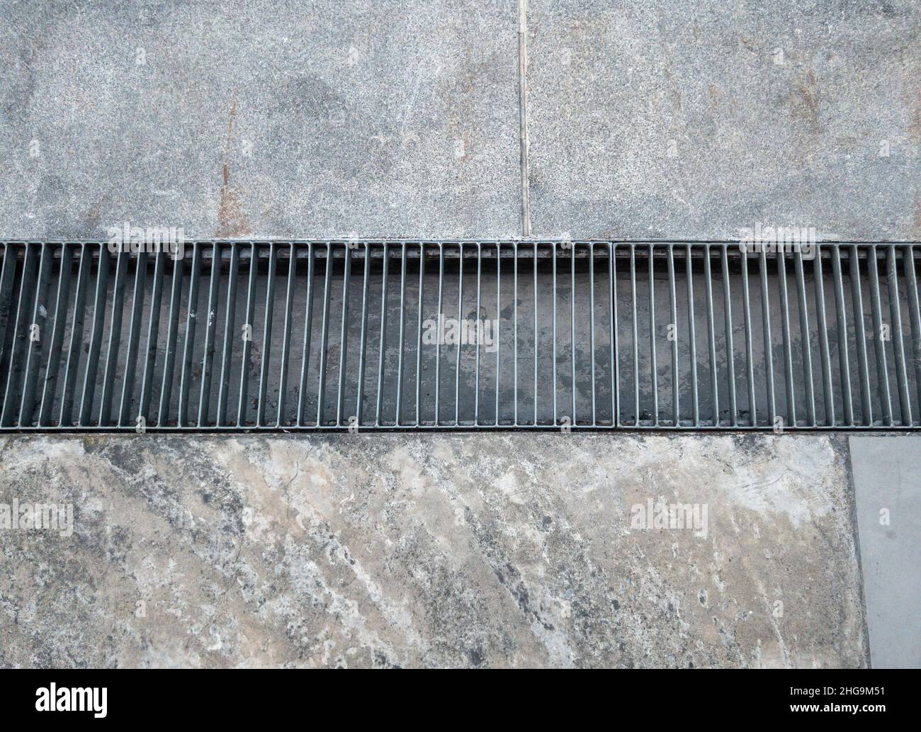 The metal grating of the drainage channel near the pavement in front of ...