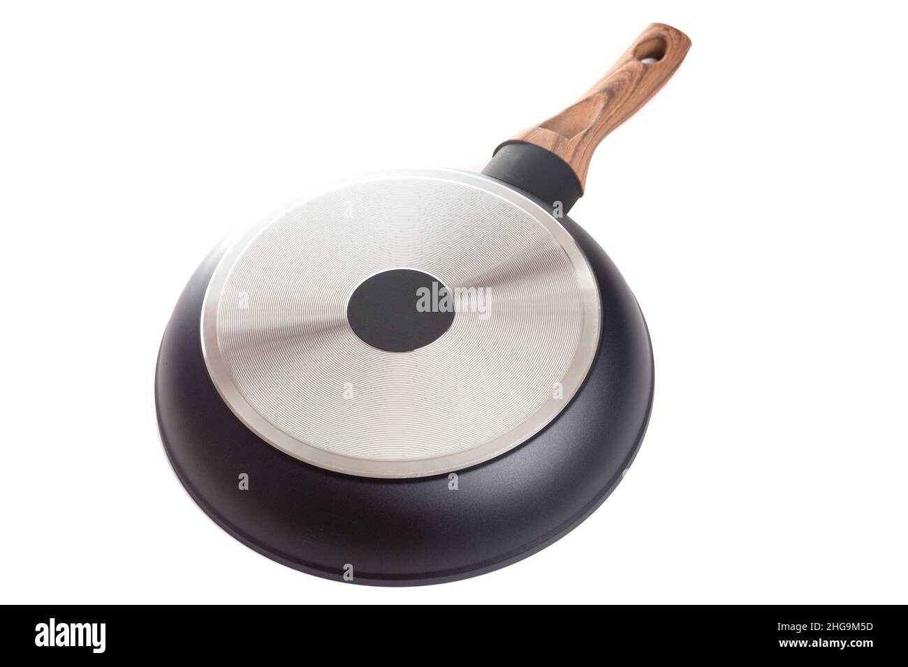 upside down black frying pan with brown handle on white background ...