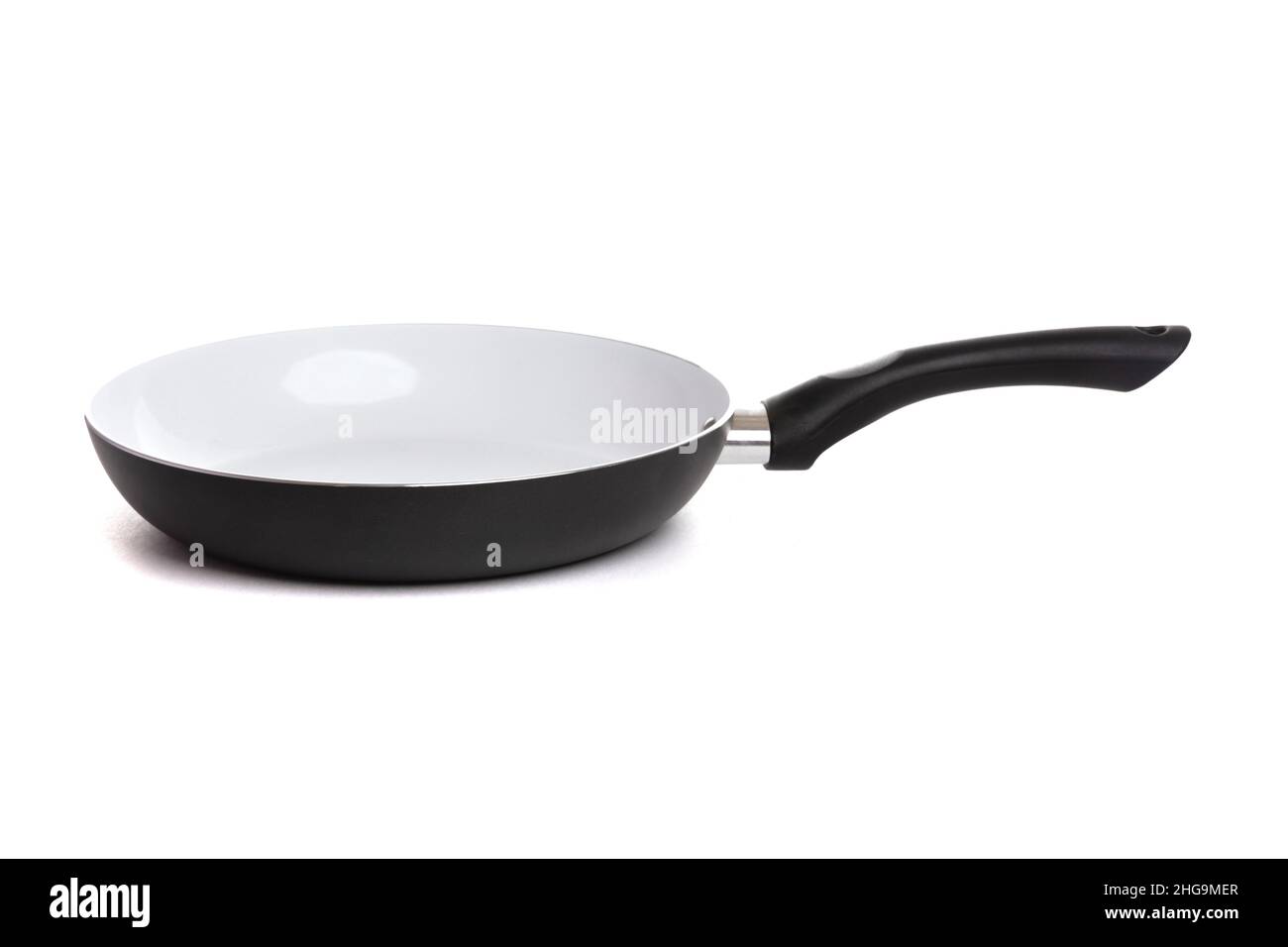 a large dark-colored kitchen pan with a black handle with a white non ...