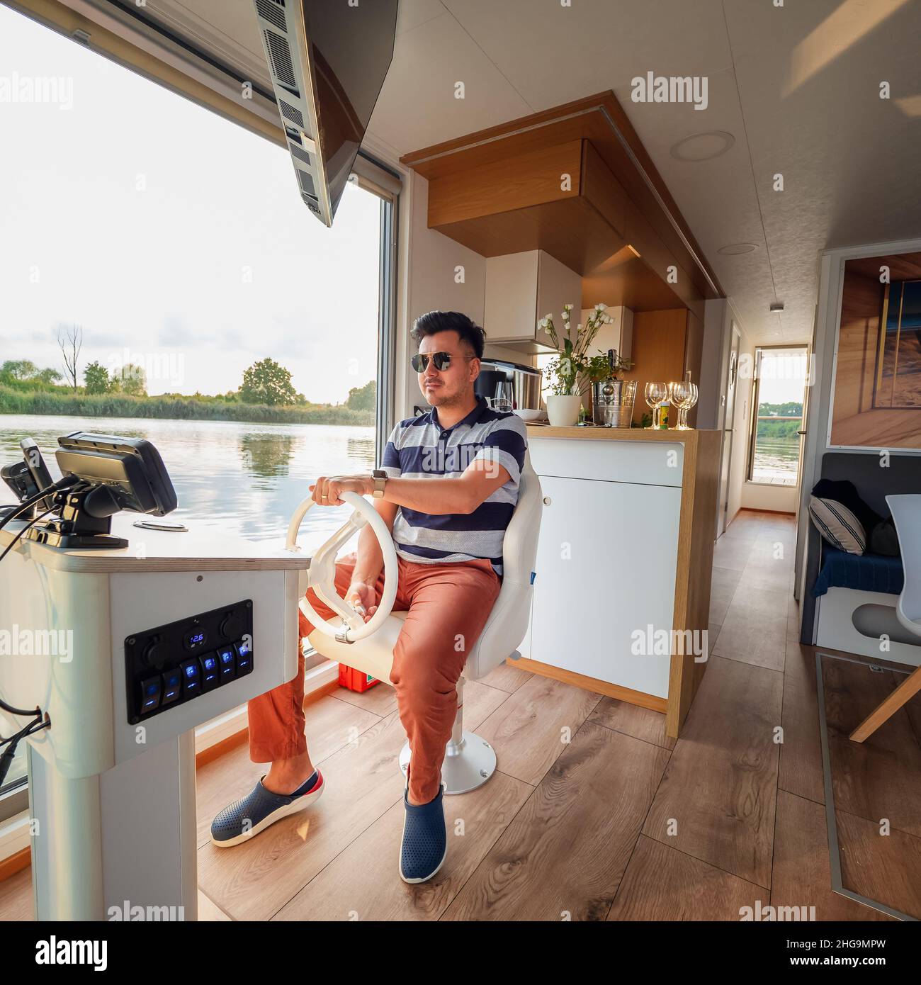 Summer vacation travel on barge boat or houseboat on a river, man by ...