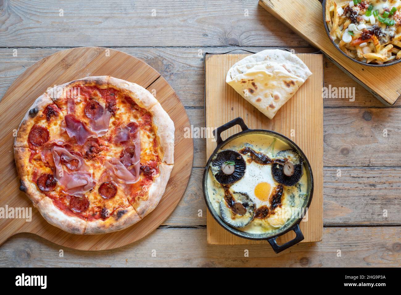 Delicious artisan meat feast pizza and cast iron skillet cheesy egg and ...