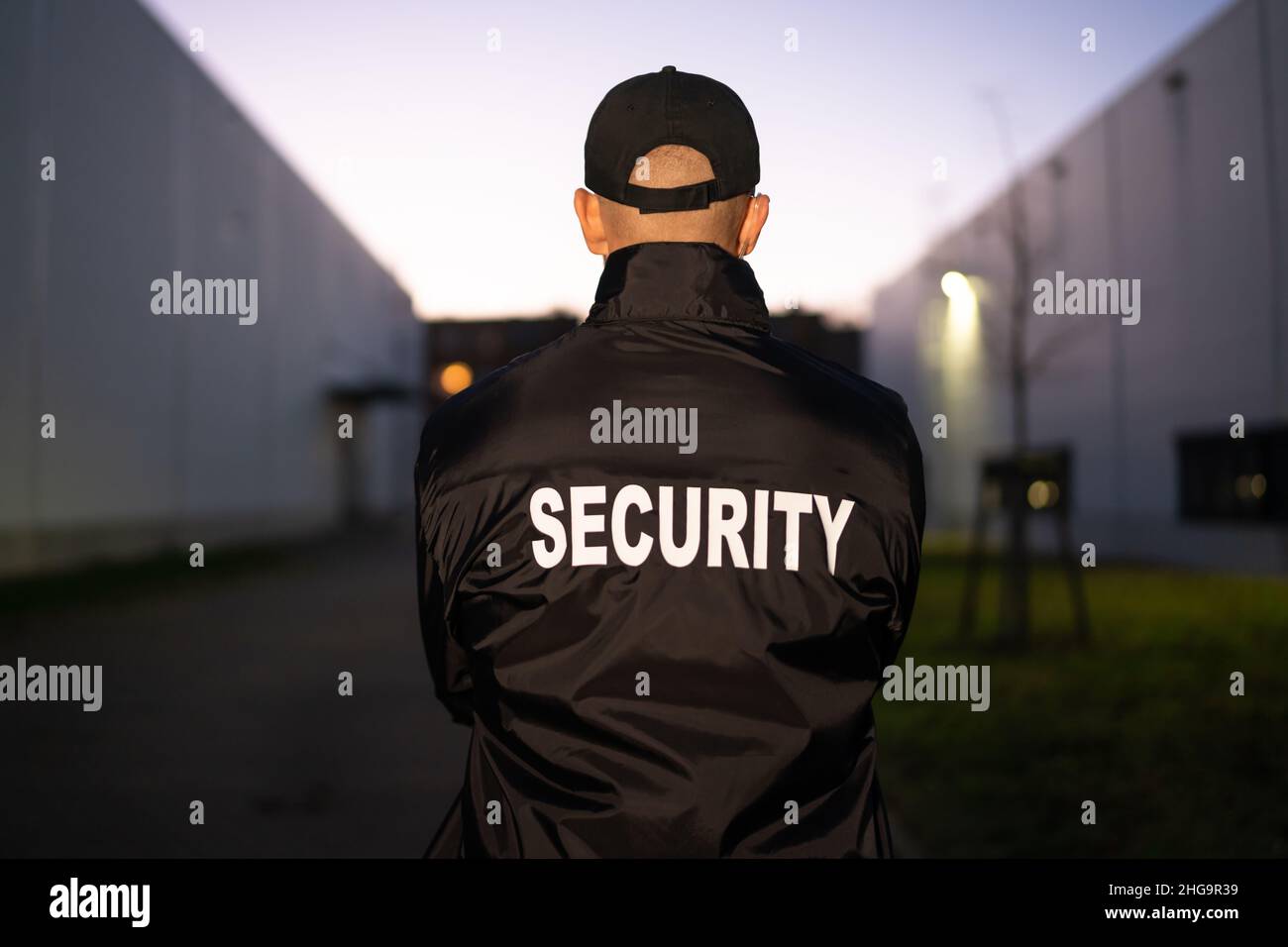 Security Guard Securing Building At Night In Alley Stock Photo - Alamy