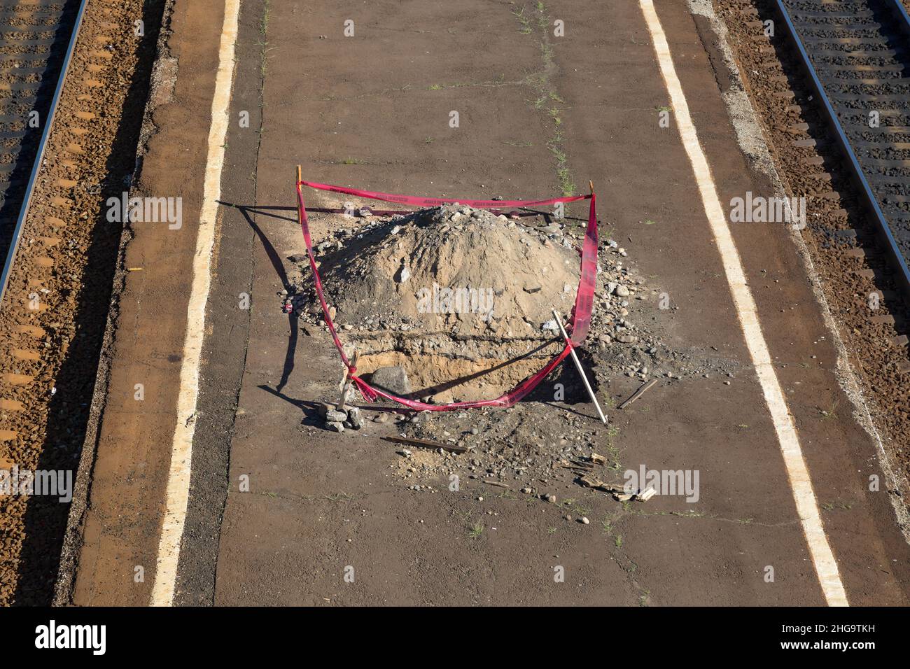 A pit surrounded by a red ribbon railway tracks near the station Stock ...