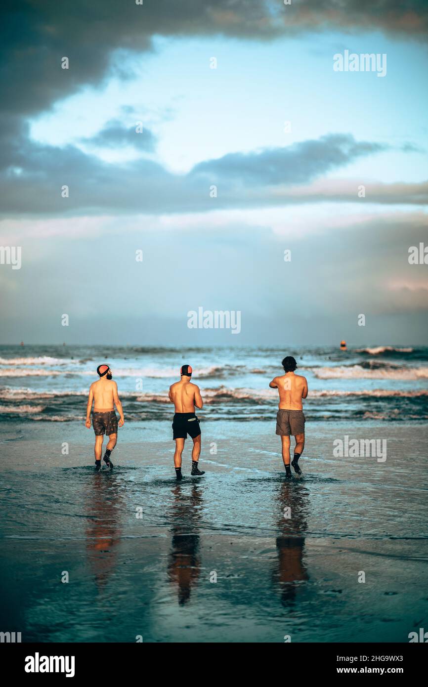 Three men going for a morning swim Stock Photo - Alamy
