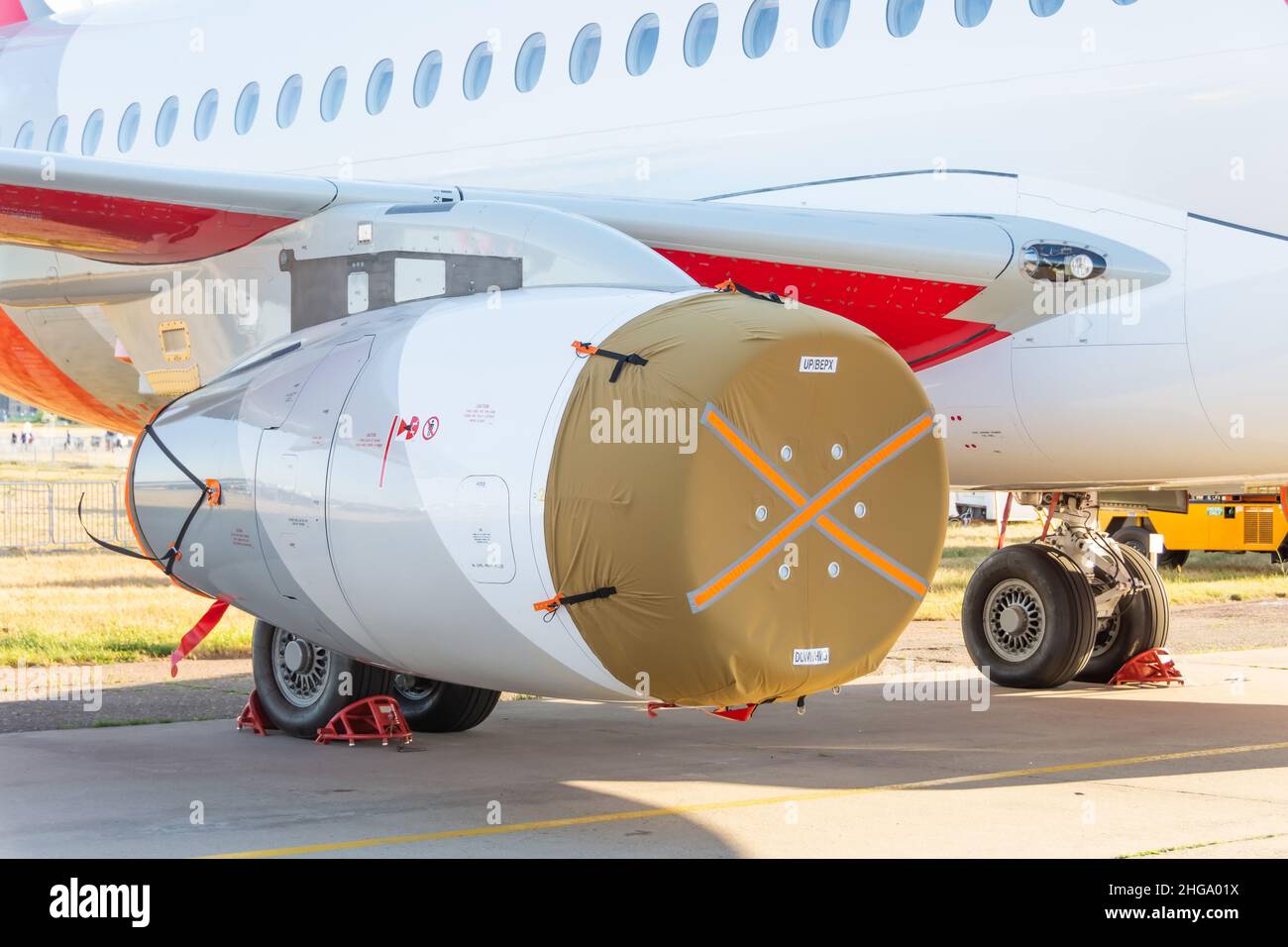 Commercial aircraft with a cover on the engine under the wing in a ...