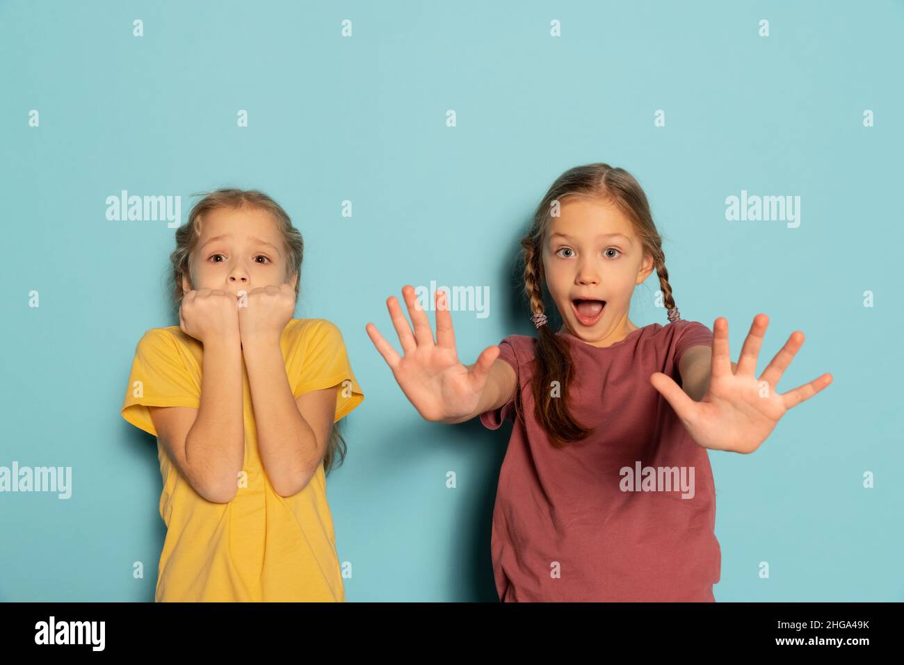 Portrait of scared little girls, sisters or siblings wearing casual ...