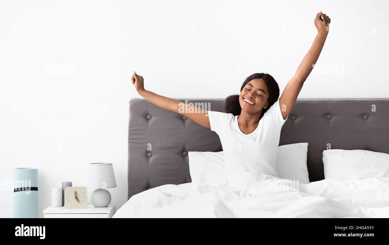 Well-rested black woman enjoying happy morning, stretching in bed Stock ...