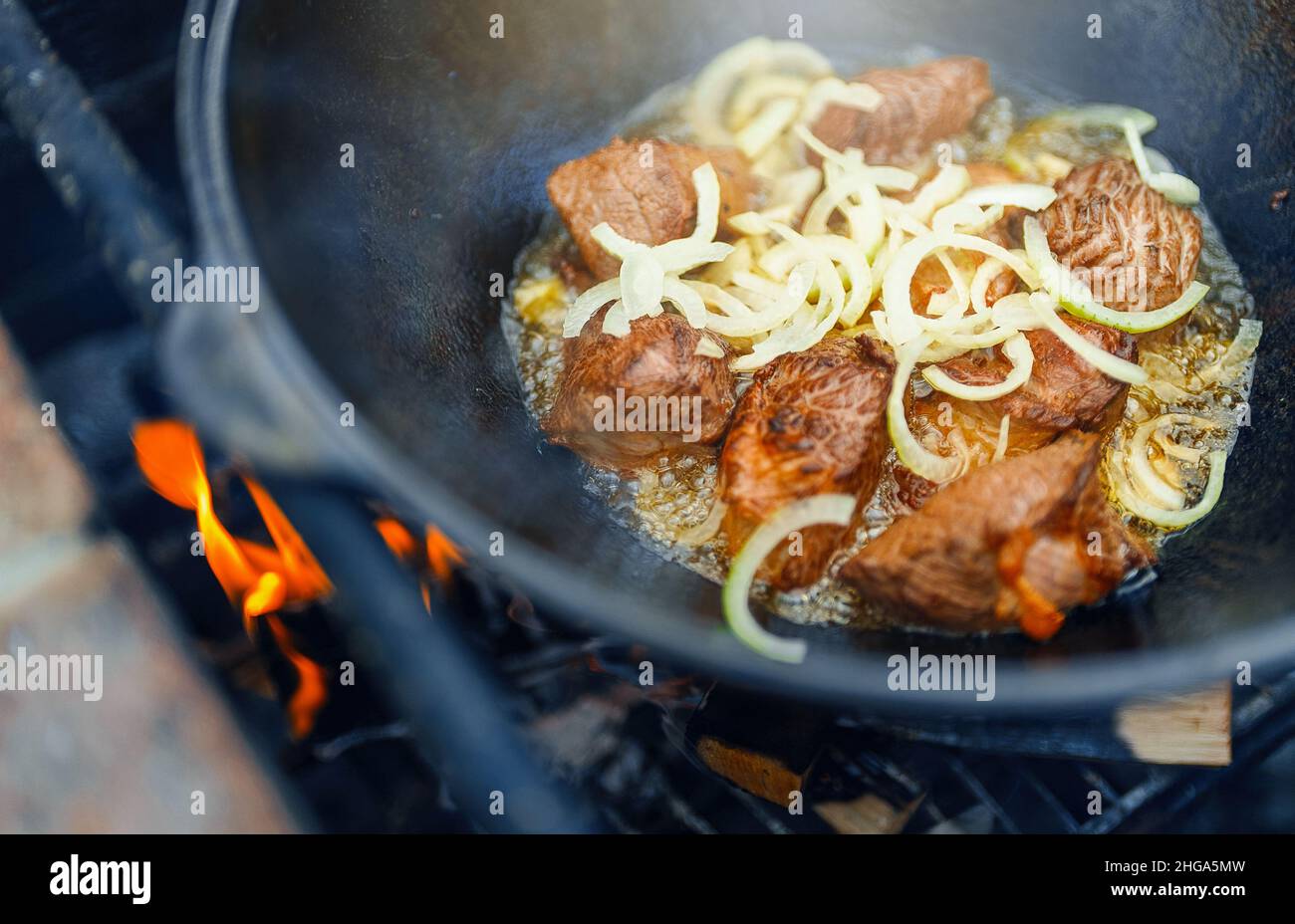 Meat is cooked in cauldron on fire. Step by step cooking of Pilaf Stock ...