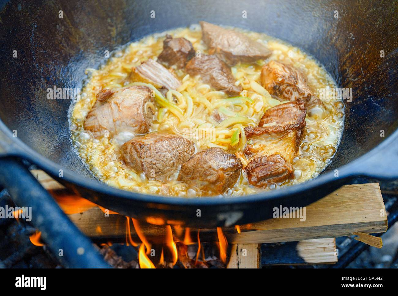 Meat is cooked in cauldron on fire. Step by step cooking of Pilaf Stock ...
