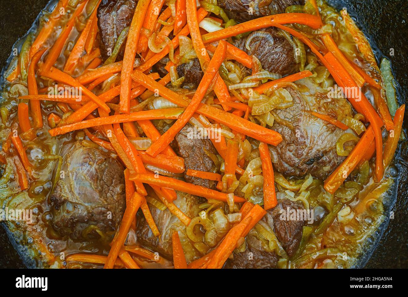 Meat is cooked in cauldron on fire. Step by step cooking of Pilaf Stock ...